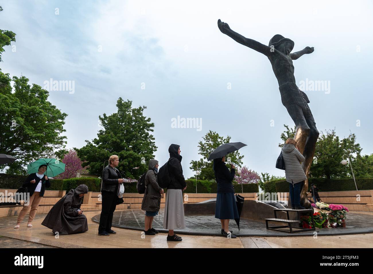 People venerating the statue of the Risen Christ in Medjugorje. The ...