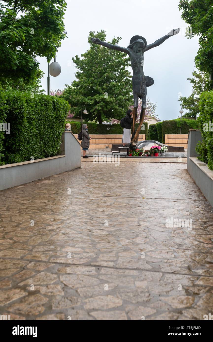 People venerating the statue of the Risen Christ in Medjugorje. The ...