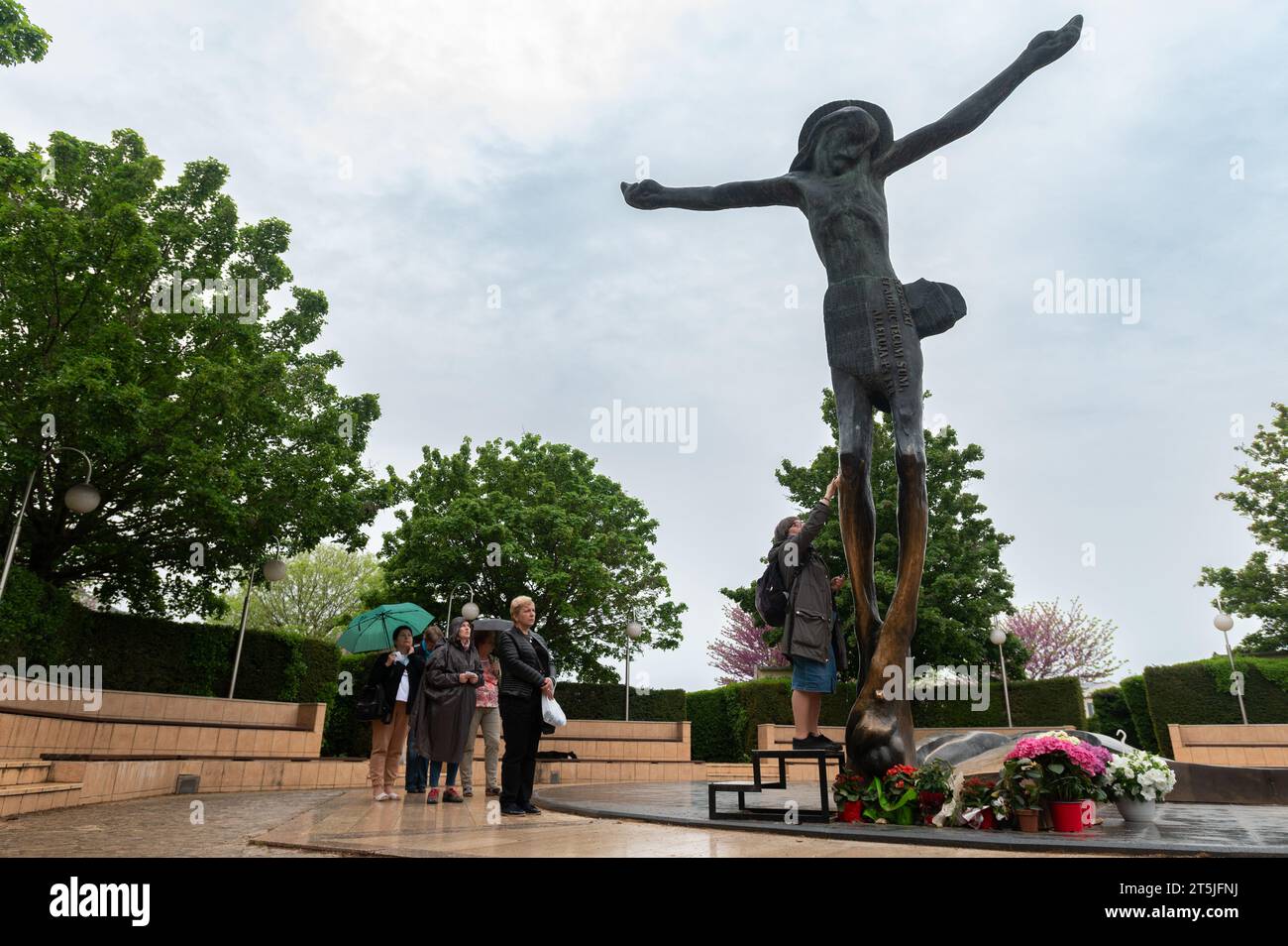 People venerating the statue of the Risen Christ in Medjugorje. The ...