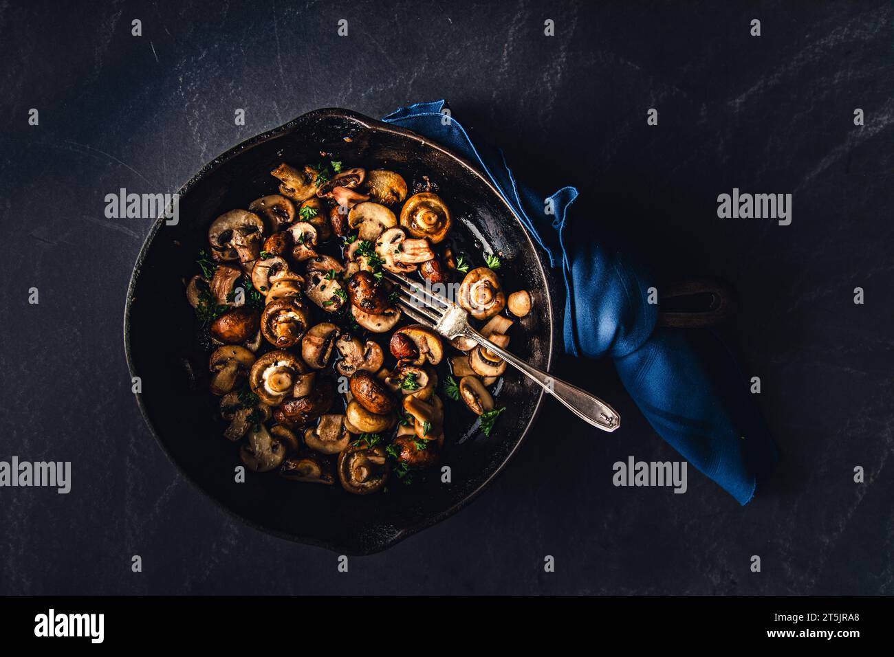 cooked mushrooms, in a cast iron fry pan on a black background Stock ...