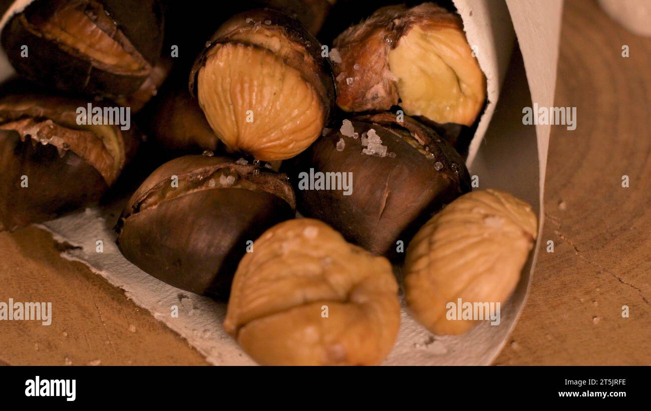 Roasted chestnuts in a paper cone, on a rustic kitchen countertop Stock ...