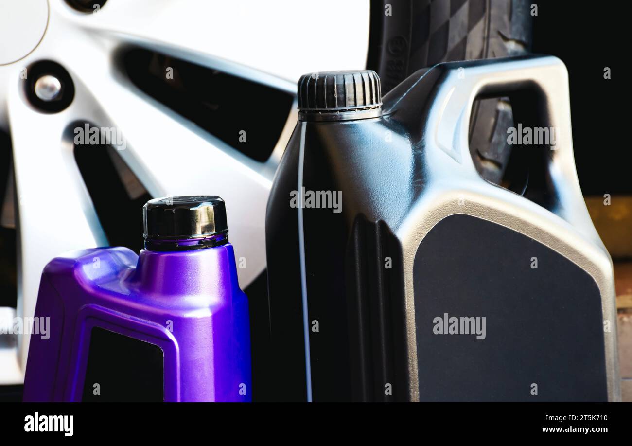 Engine oil gallon and motor oil bottle with a grey car wheel on ...
