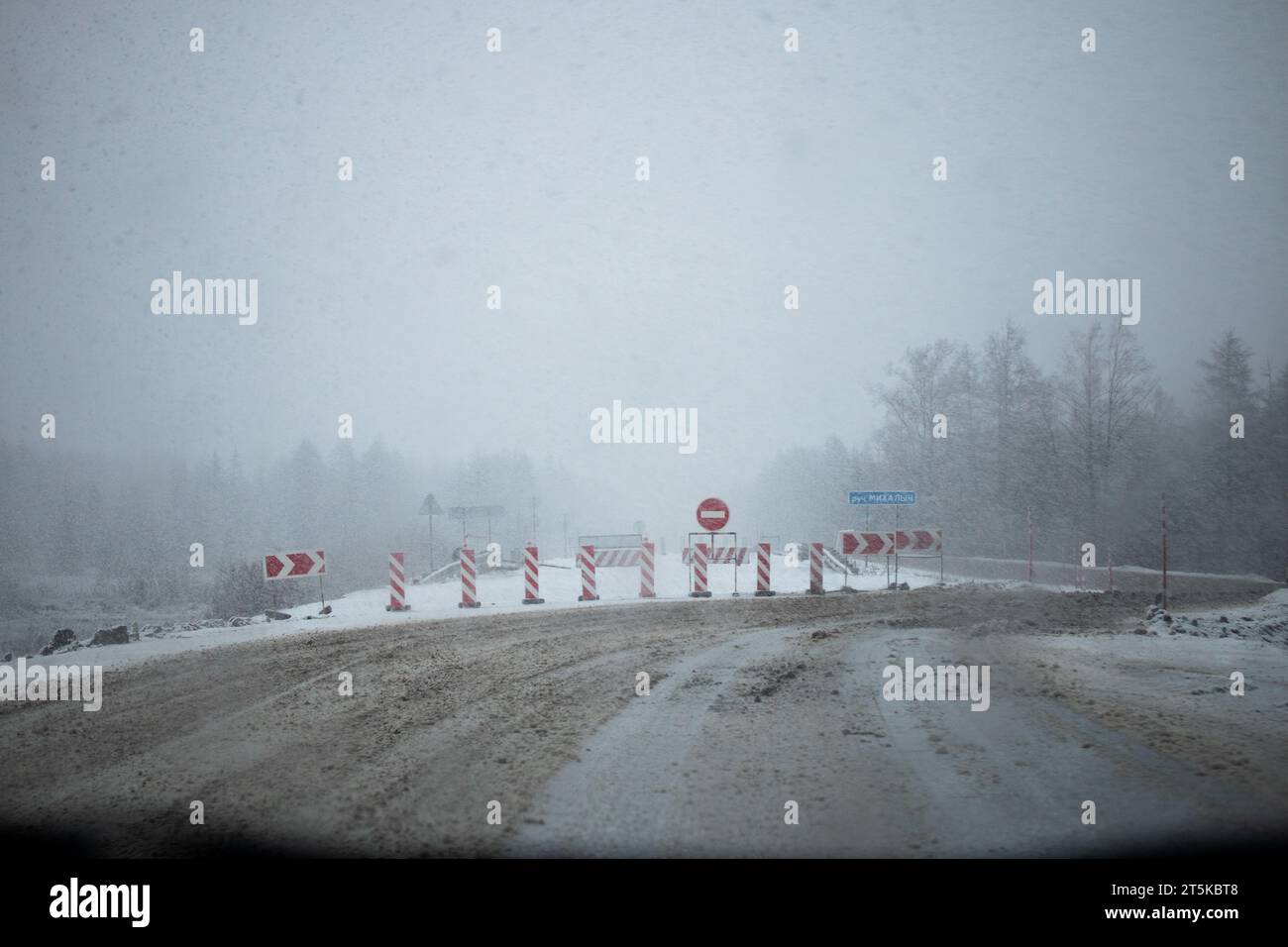 Photo of detour road signs covered with snow during the snowfall in ...