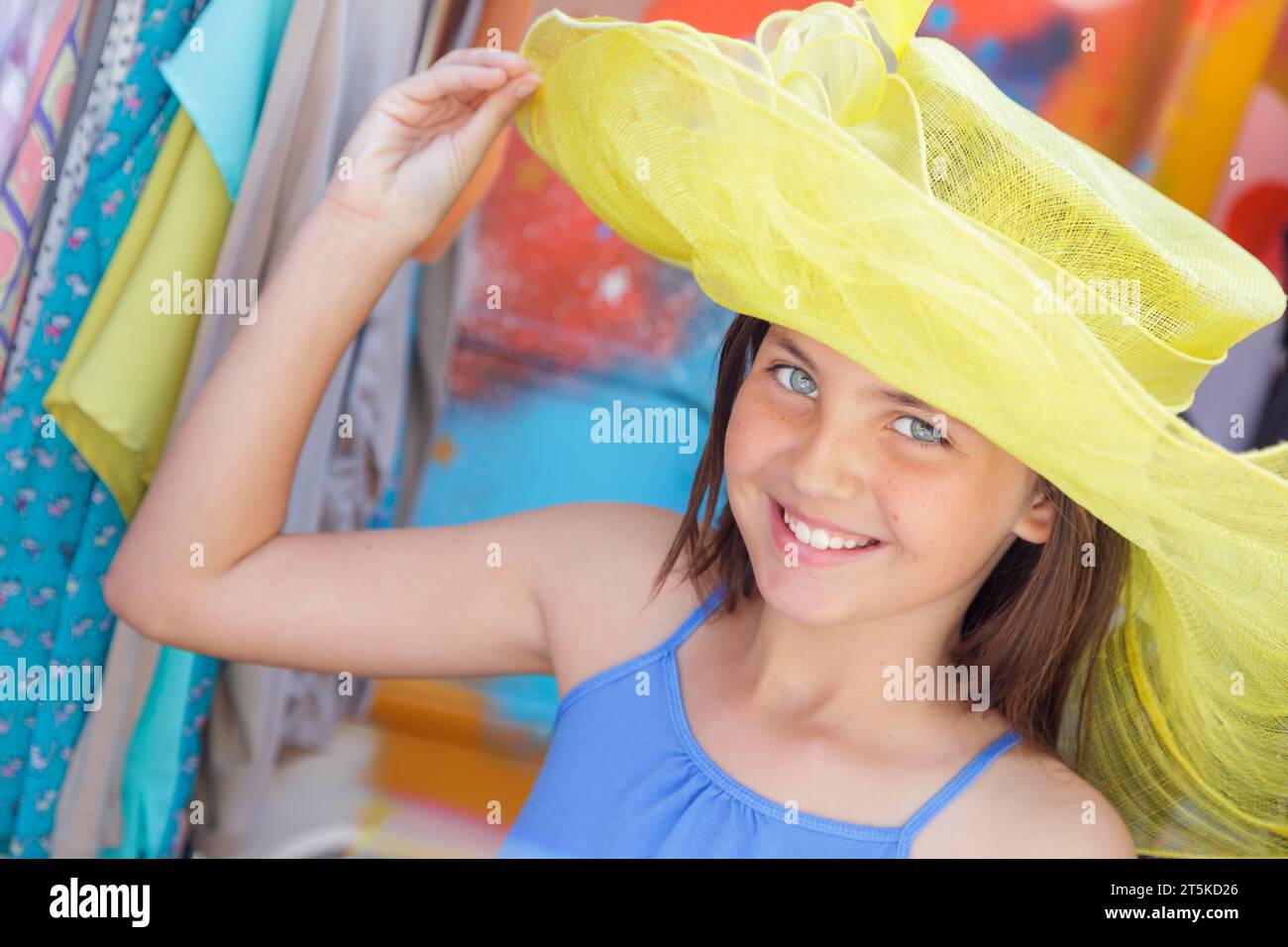 Cute Blue Eyed Girl Playfully Modeling a Big Sun Hat at the Market ...