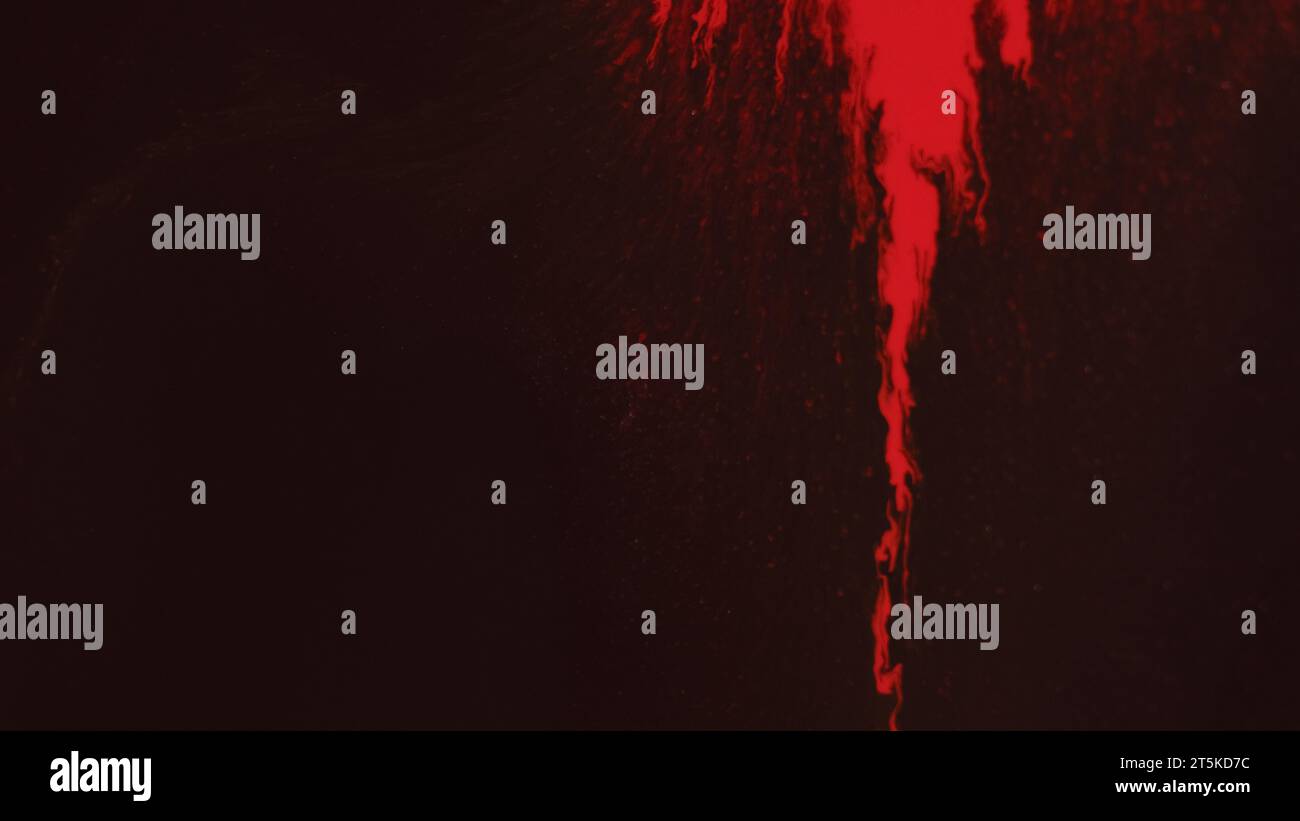 Paint pouring glitter ink spill red dye black Stock Photo - Alamy