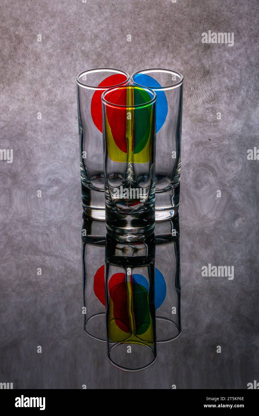 Still life with glass objects with colored spots on a reflective ...