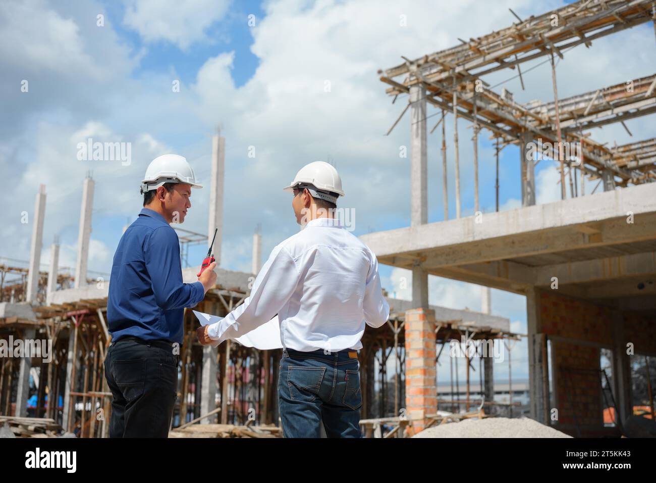 Two engineer working and checking plan on construction site Stock Photo ...