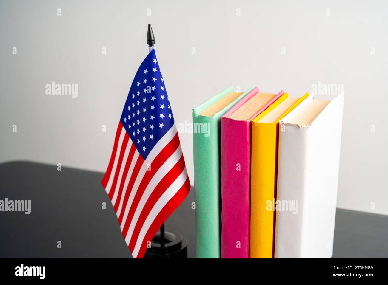USA flag with pile of books against white background Stock Photo - Alamy
