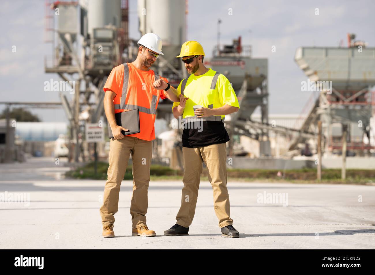 Two engineers workers, industry factory workers outdoor. Factory ...