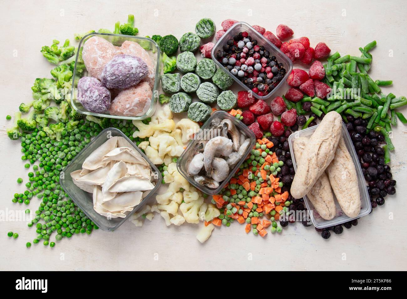 Frozen food, vegetables, fruits, meat, bread and fish on a white ...