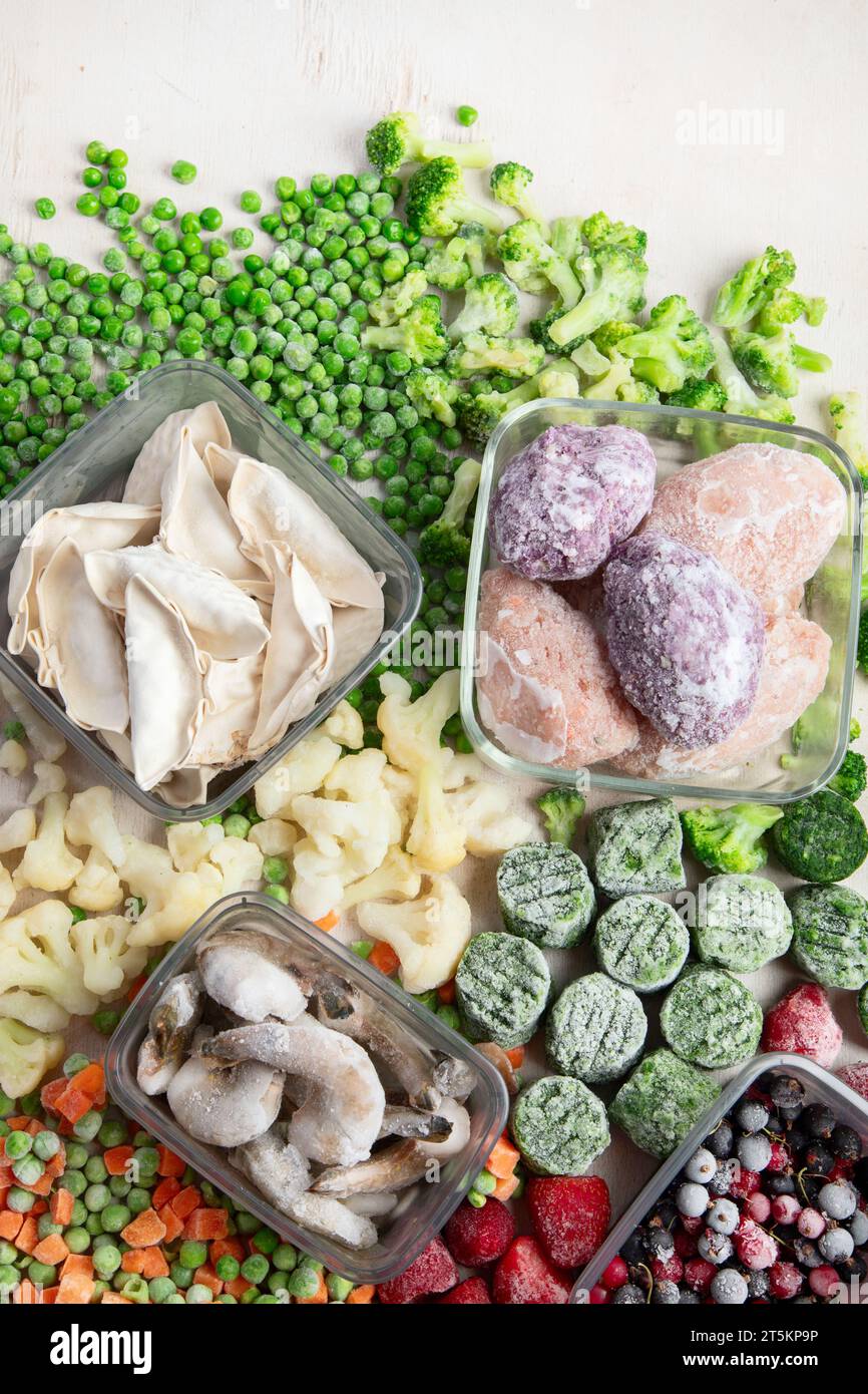 Frozen food, vegetables, fruits, meat, bread and fish on a white ...