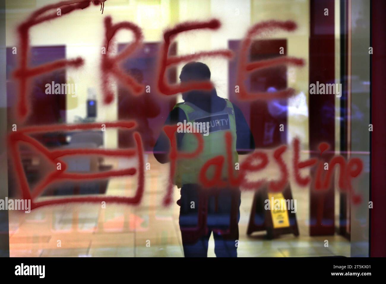 A security worker stands in the reception area behind windows sprayed ...