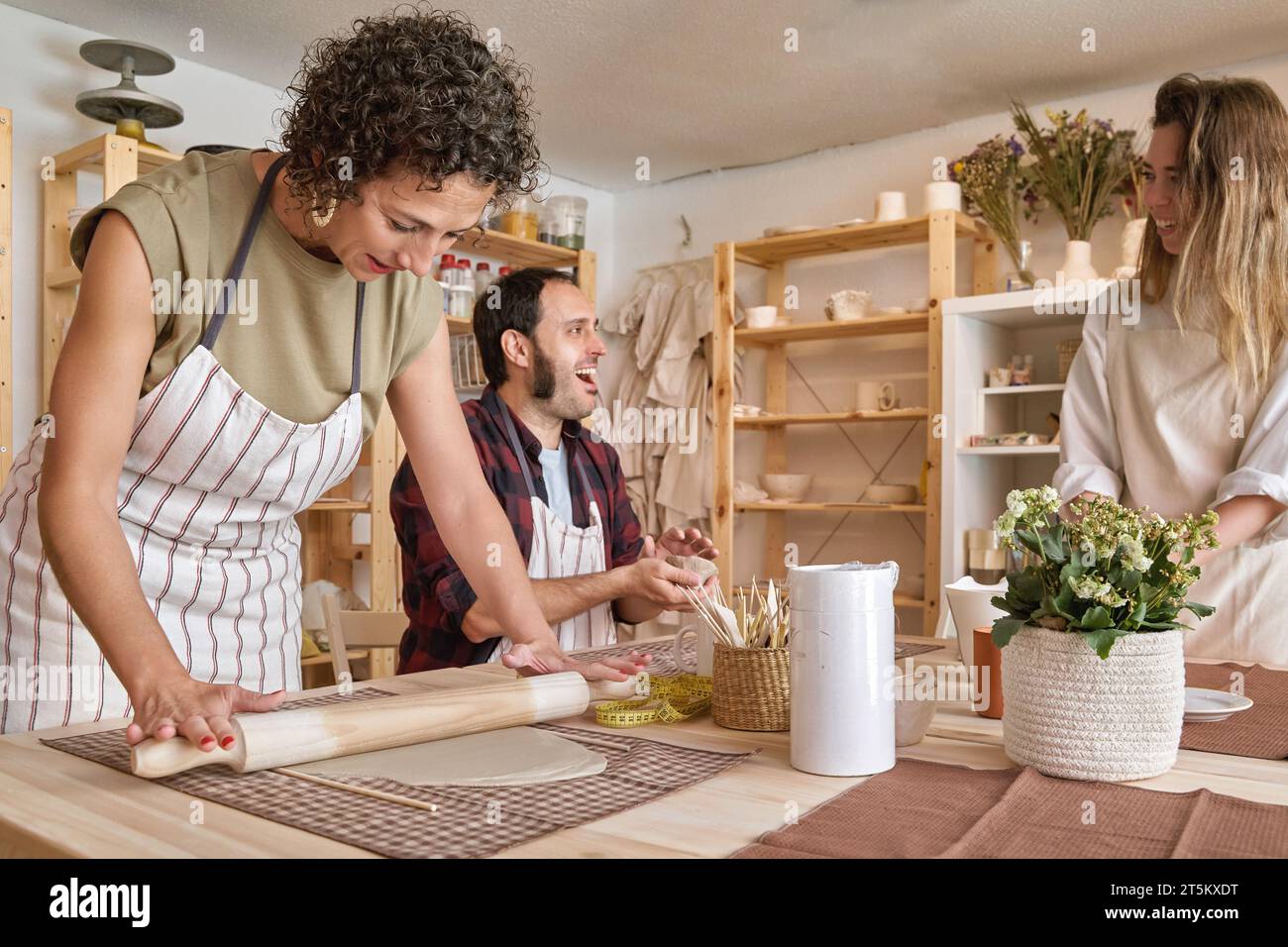 Group of people having fun while creating crafts in pottery workshop ...