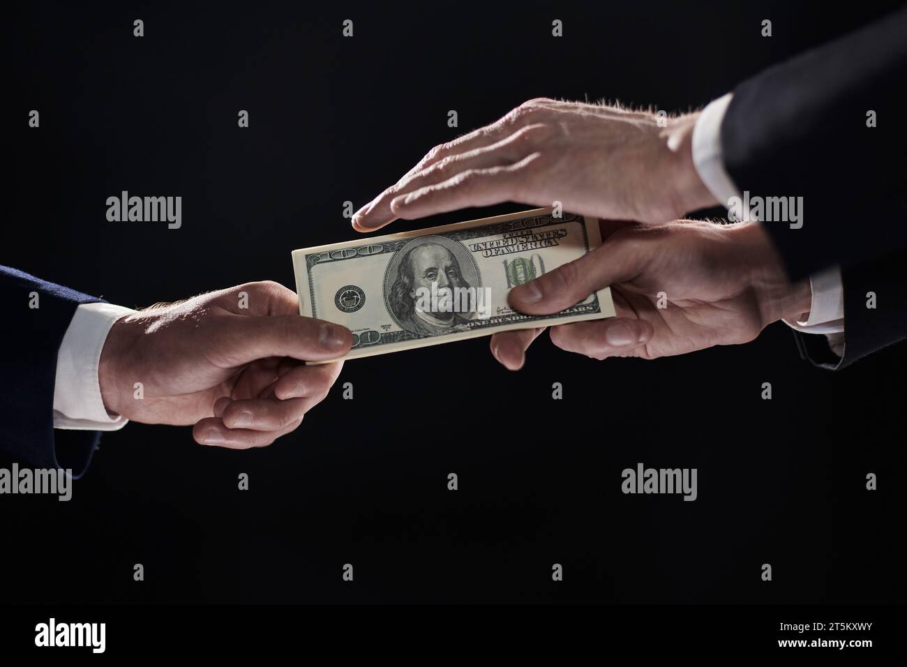 transferring money from hand to hand on a black background Stock Photo ...