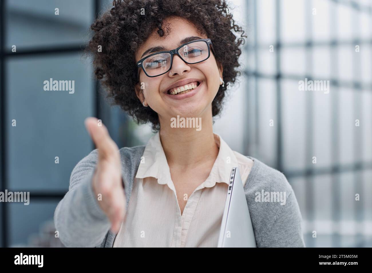 businesswoman offering handshake, standing with extended hand in modern ...