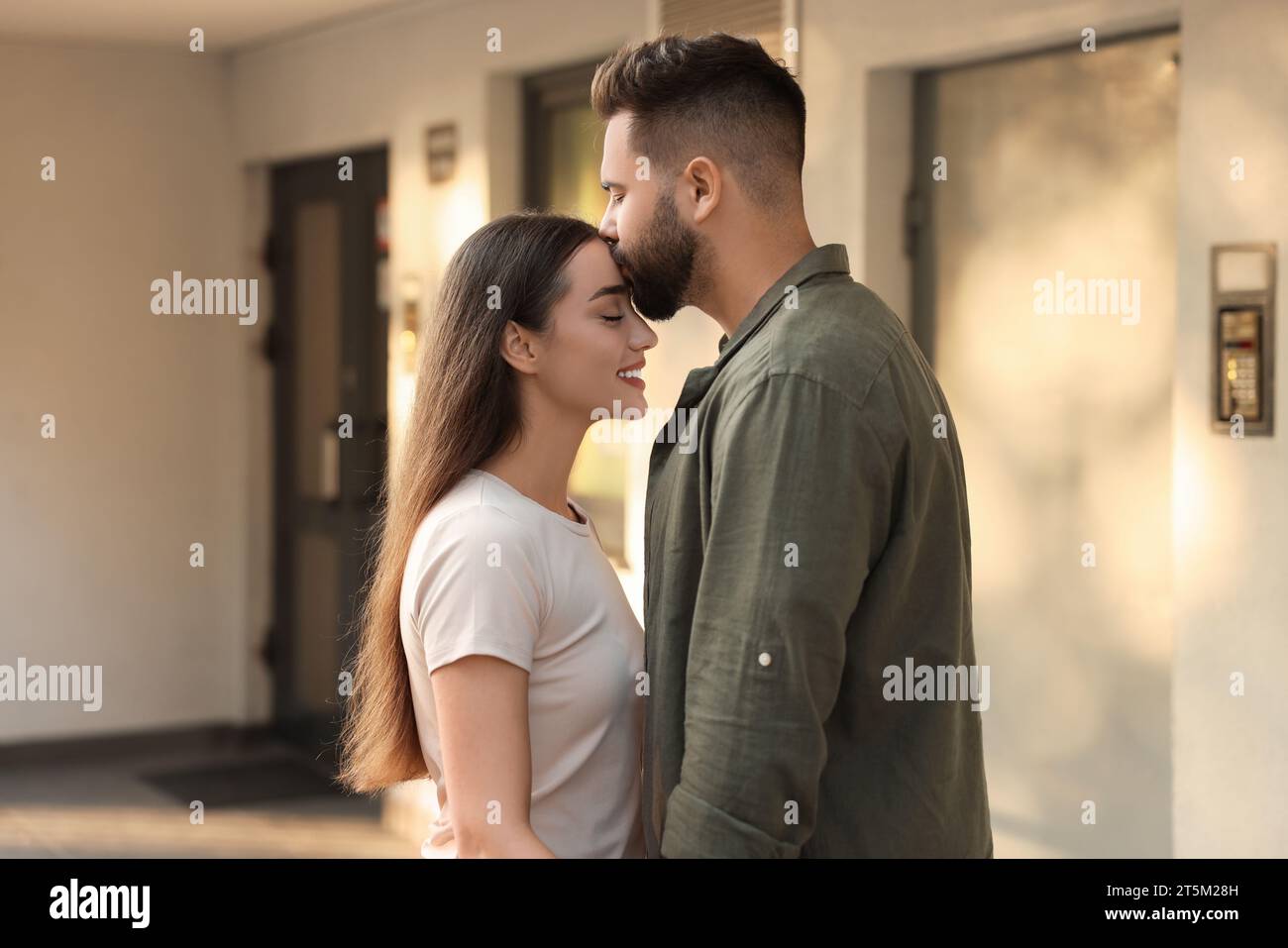 Long-distance relationship. Man kissing his girlfriend near house ...