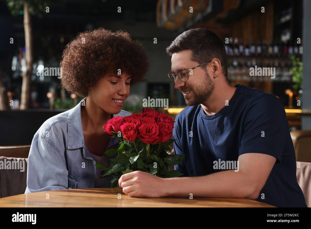 International relationships. Handsome man presenting roses to his ...