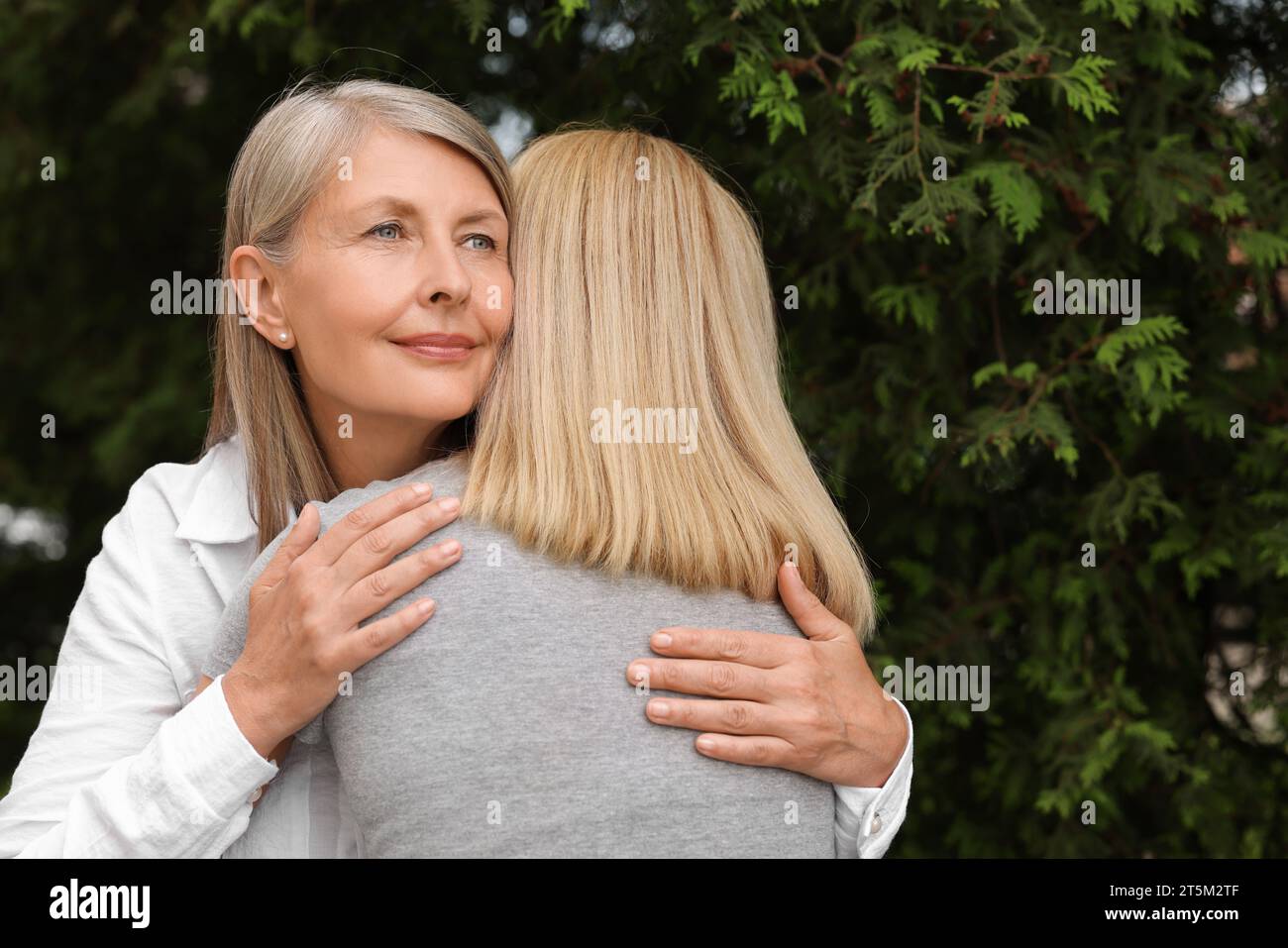 Happy mature mother hugging her daughter outdoors Stock Photo - Alamy