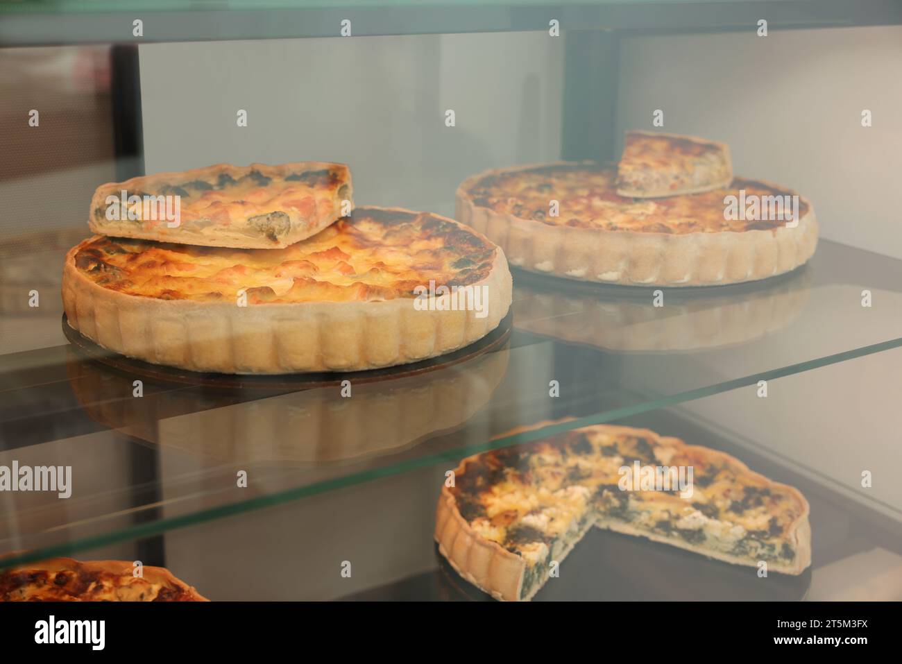 Different delicious quiches on counter in store Stock Photo - Alamy