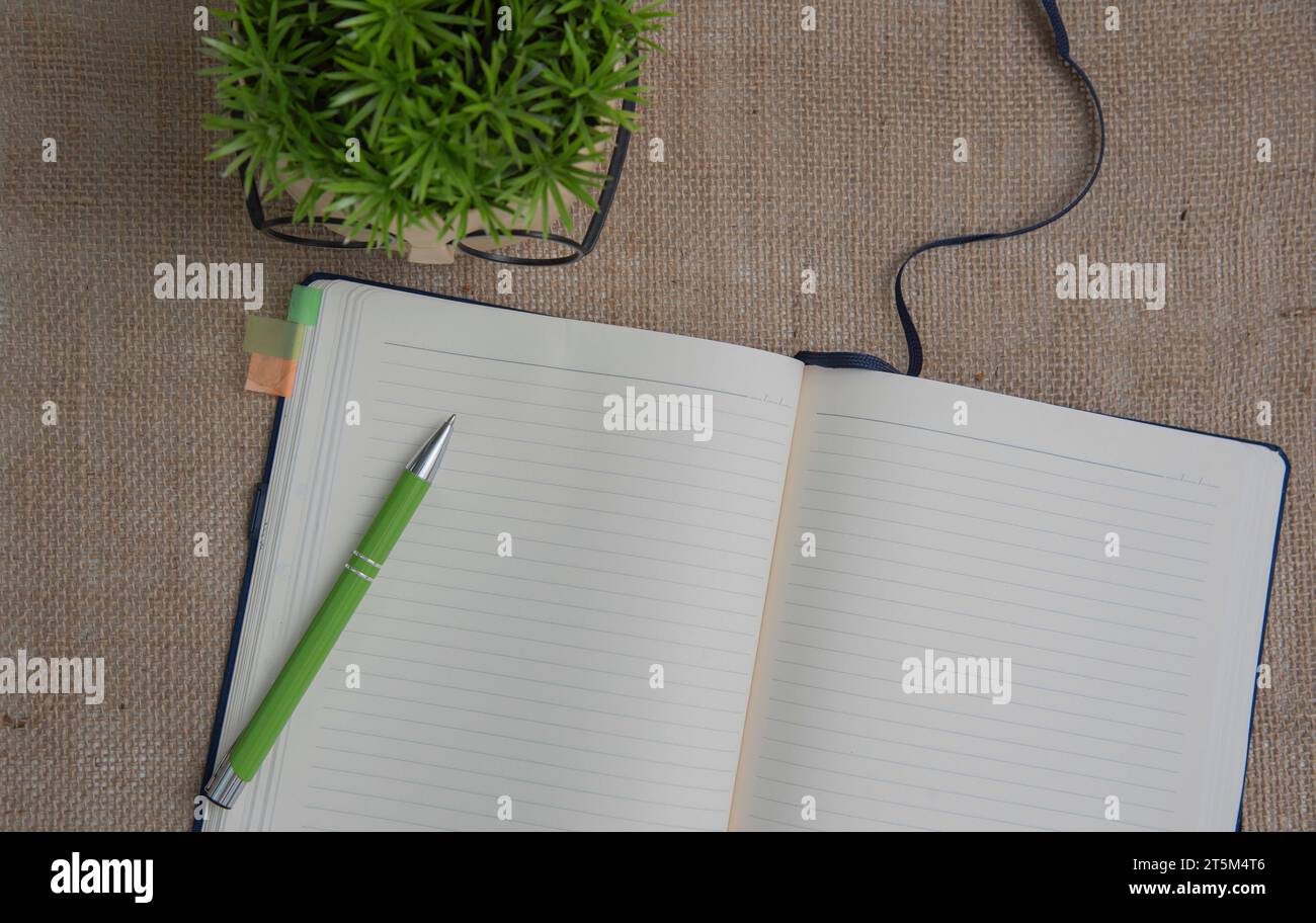 Open blank notepad with empty white pages laying on a table. cozy home ...