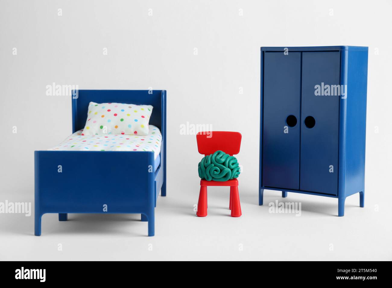 Brain made of plasticine on chair and mini furniture against white ...