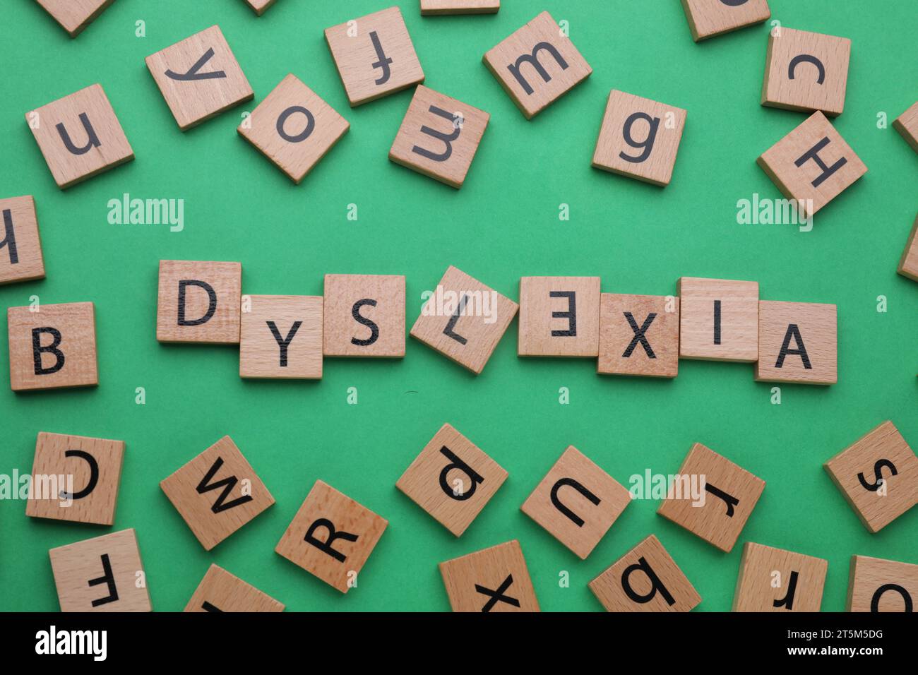 Word Dyslexia with inverted letter E of wooden tiles on green ...