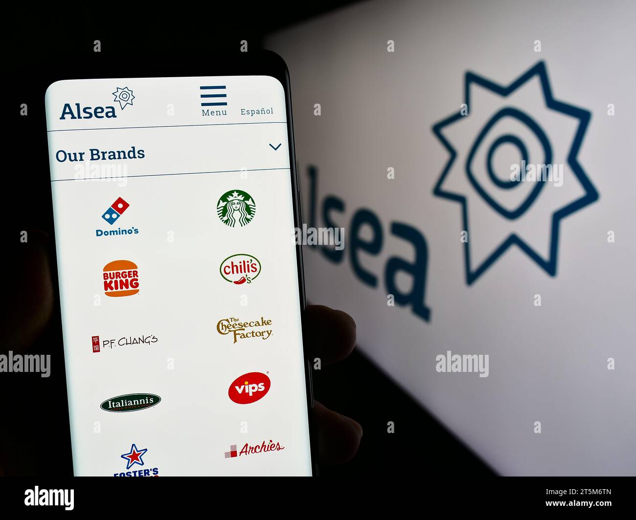 Person holding mobile phone with web page of Mexican restaurant company ...