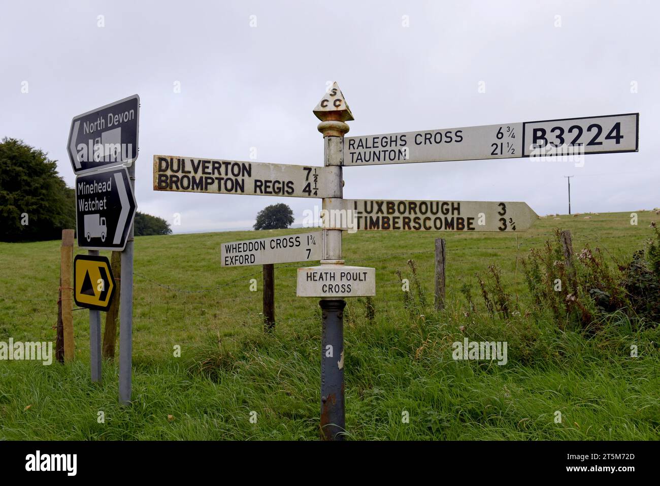 Historic road sign fingerpost at Heath Poult Cross alongside modern ...