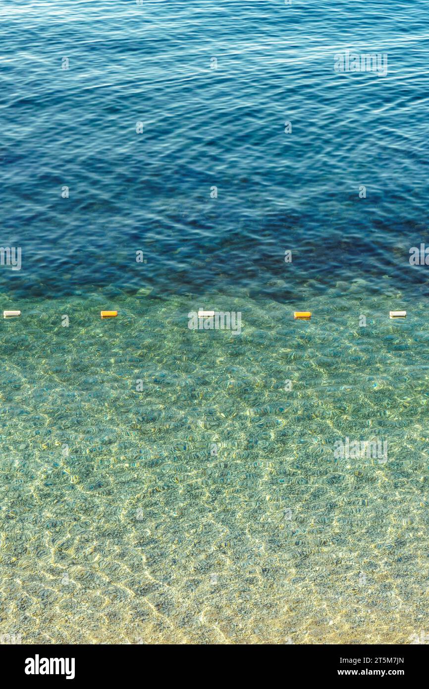 Safety buoys line floats on transparent water surface at sea resort ...