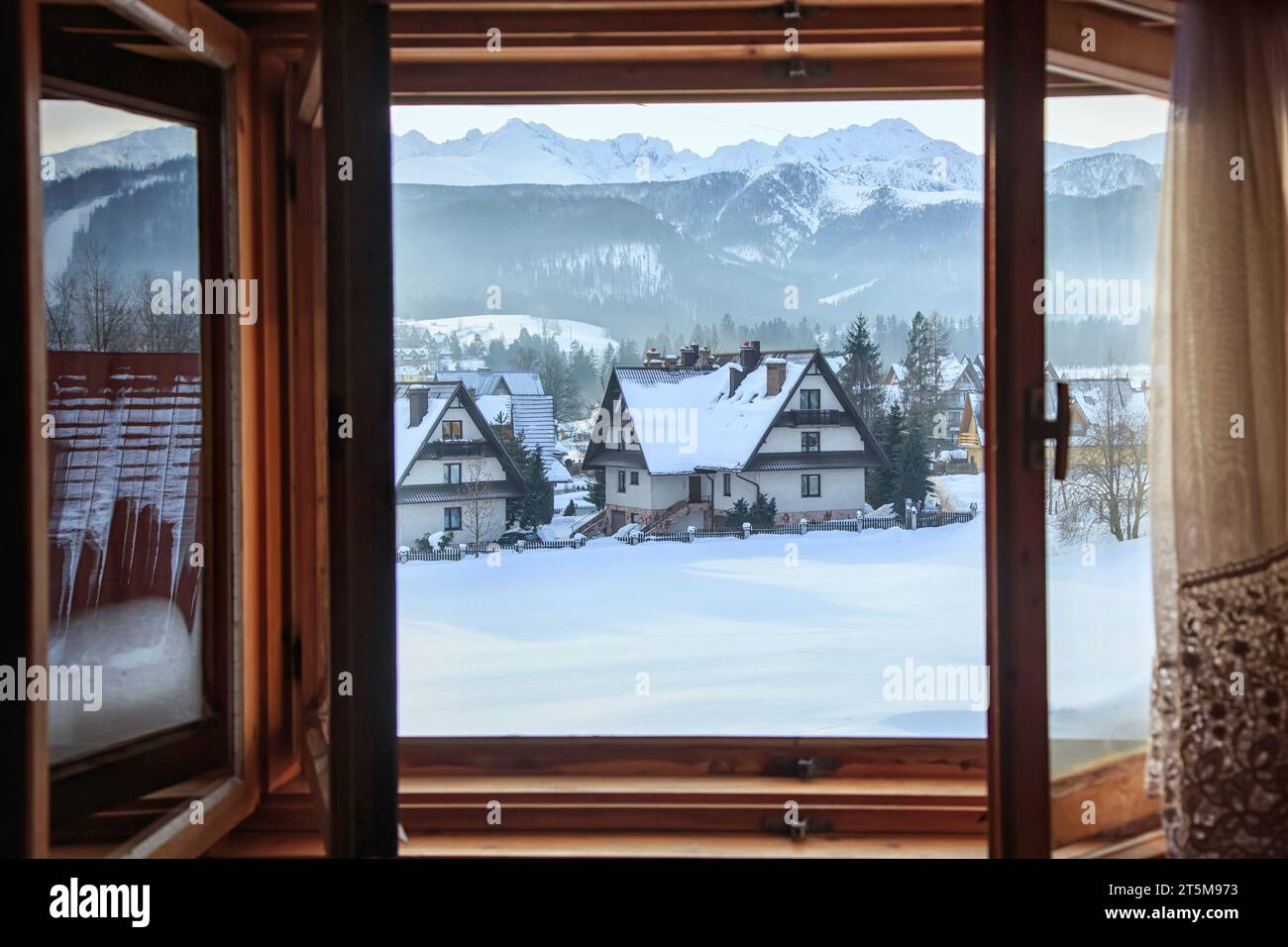 Beautiful view from an open window to a winter village with snow ...