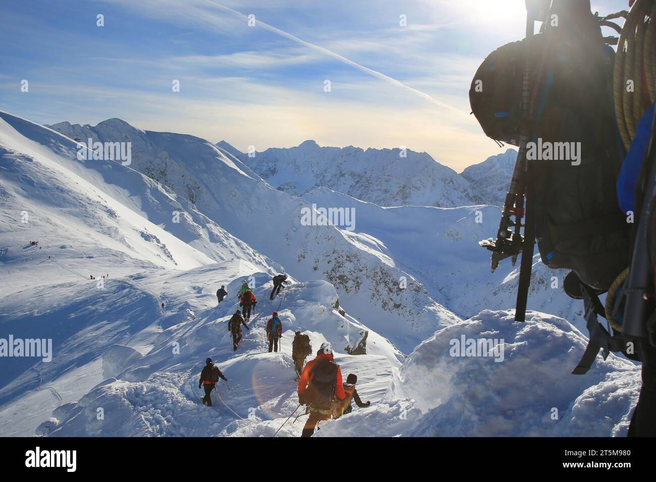 Tied climbers climbing mountain with snow field tied with a rope with ...