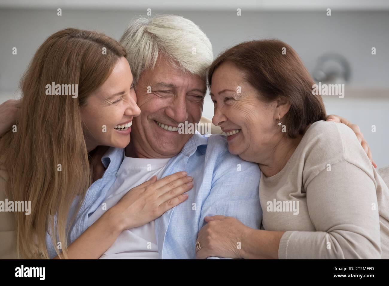 Happy mature wife and adult daughter hugging senior dad Stock Photo - Alamy