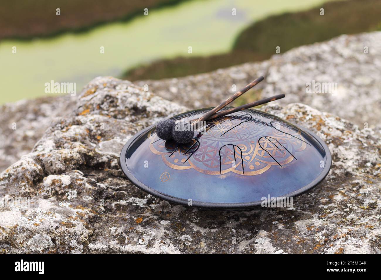 Drum sticks on hand pan percussion instrument on nature background ...