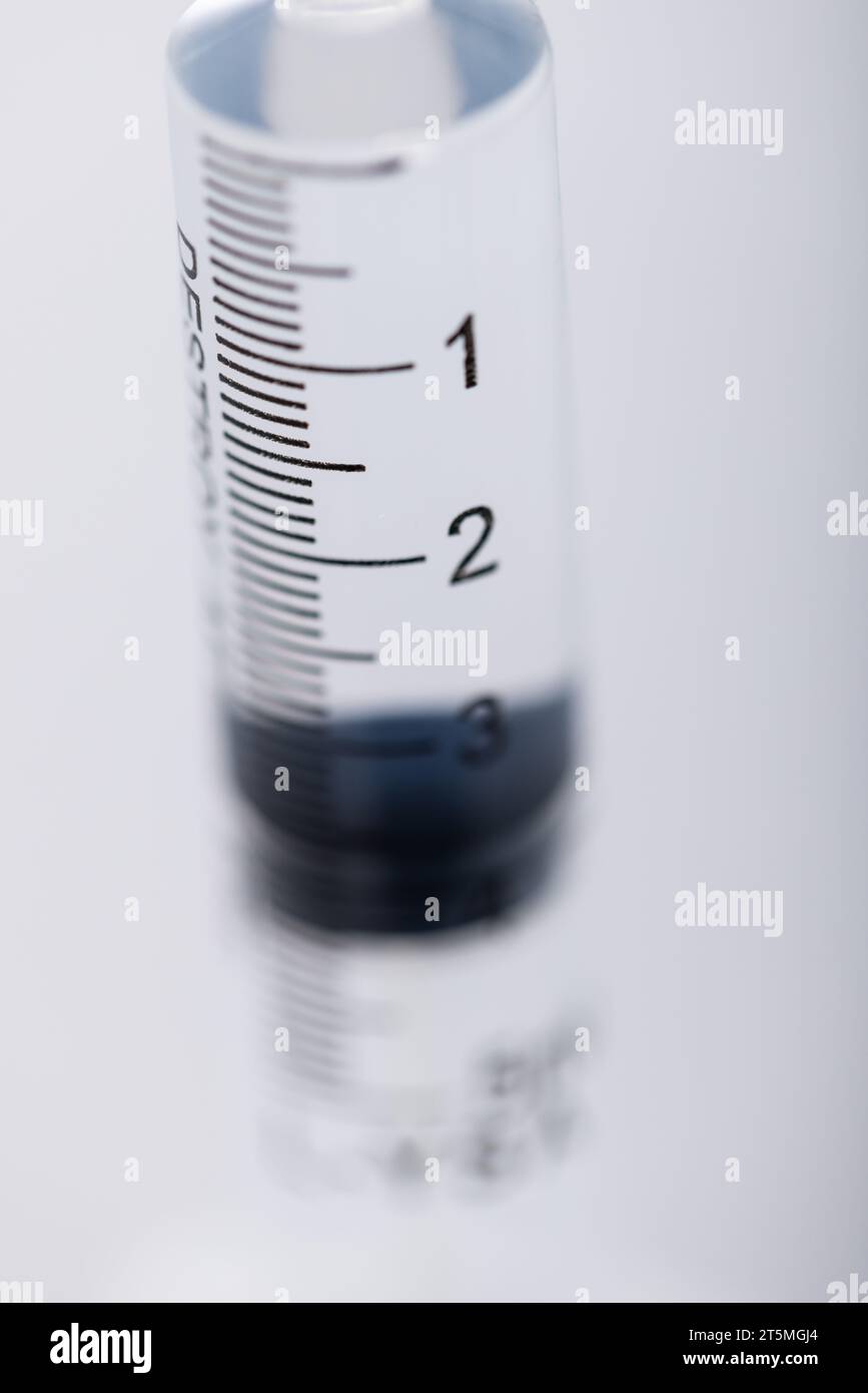 Vertical image of close up of laboratory syringe and copy space on grey ...