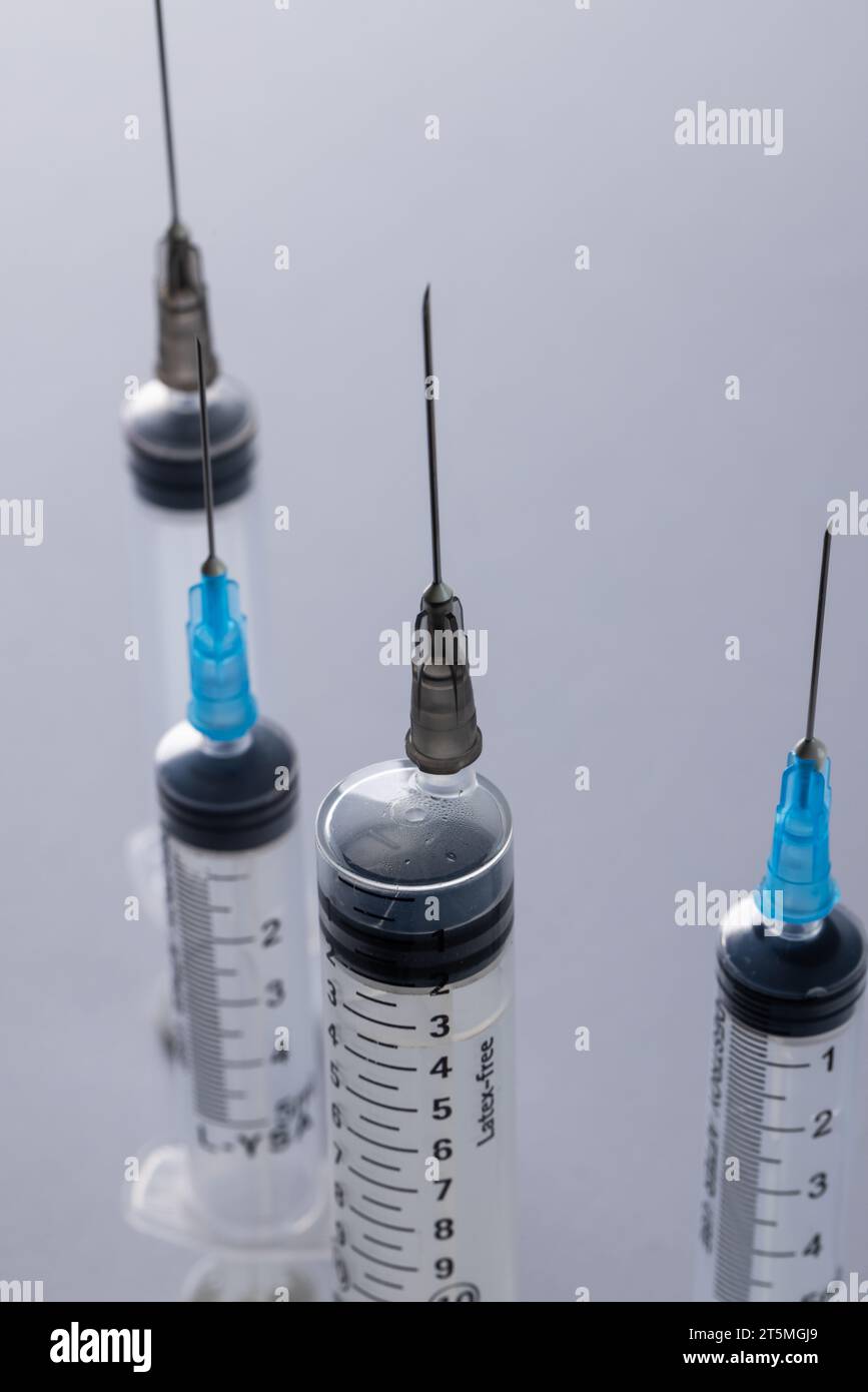 Vertical image of laboratory syringes with needles and copy space on ...
