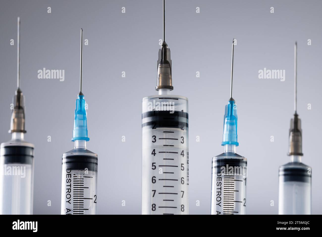 Close up of laboratory syringes with needles and copy space on grey ...