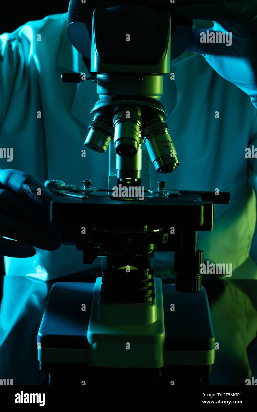 Vertical image scientist using microscope and copy space on black ...