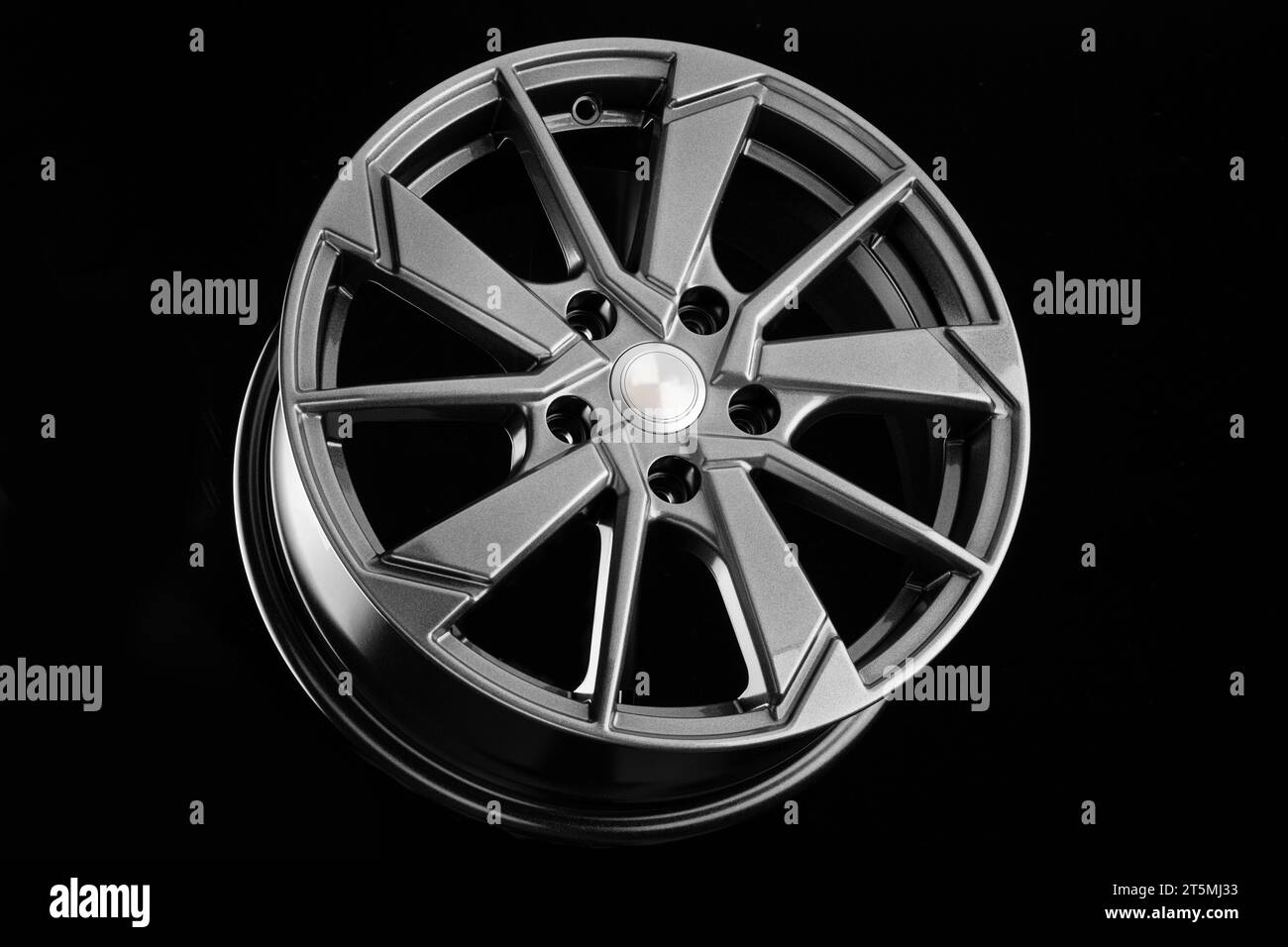 Grey modern cast disc alloy wheel on black background Stock Photo - Alamy