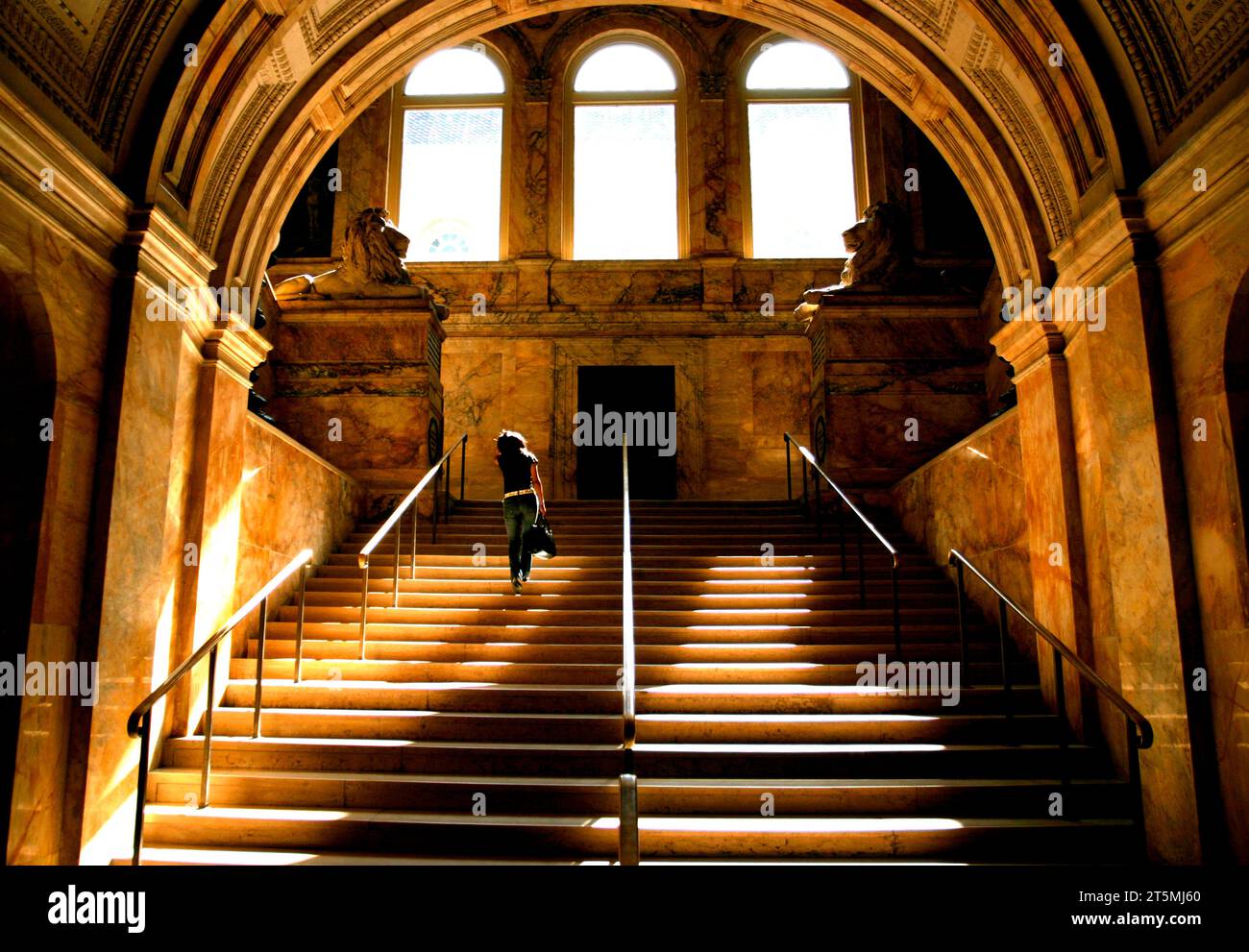 A woman walks up the stairs inside the Boston Public Library in Boston ...