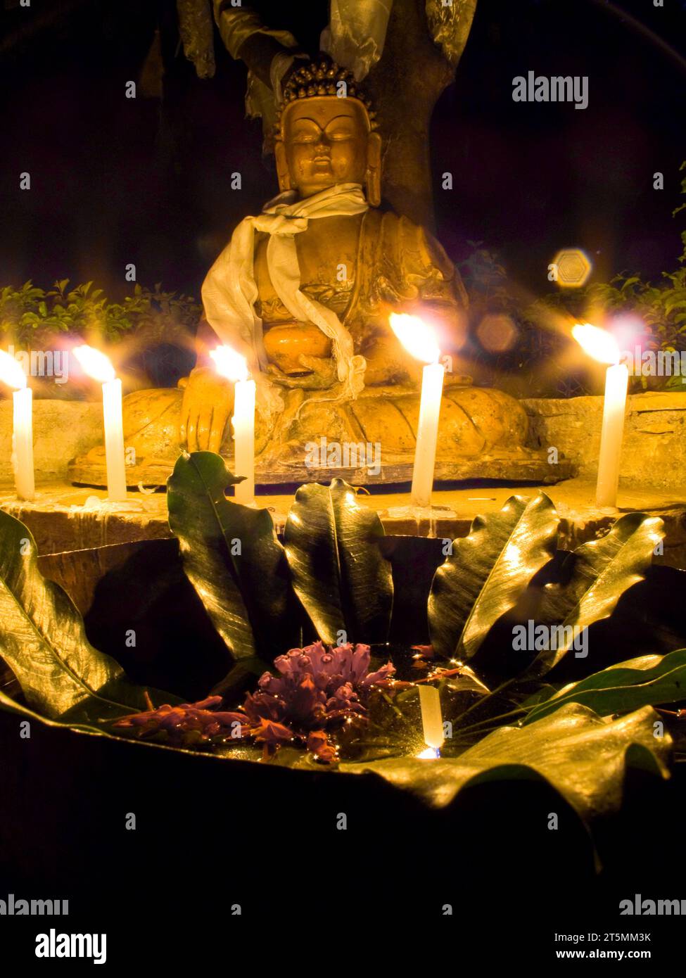 A candle lit Bhuda statue in Nepal Stock Photo - Alamy