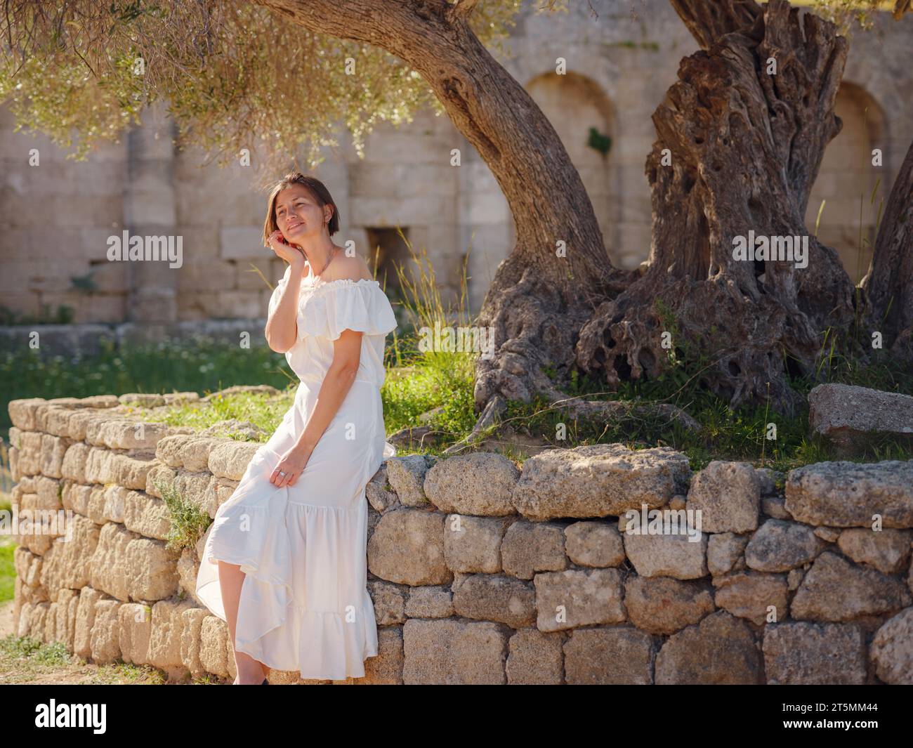 Beautiful Asian young woman in white dress outdoor. Acropolis of Rhodes ...
