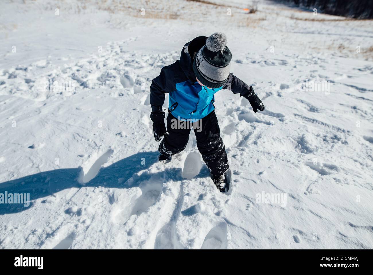 Overhead view of little boy jumping through snow with negative s Stock ...