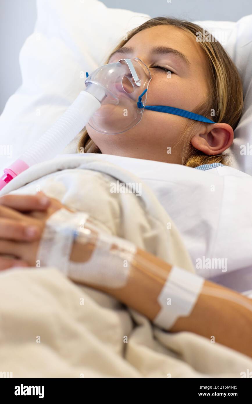 Caucasian girl patient with drip and wearing oxygen mask asleep in ...
