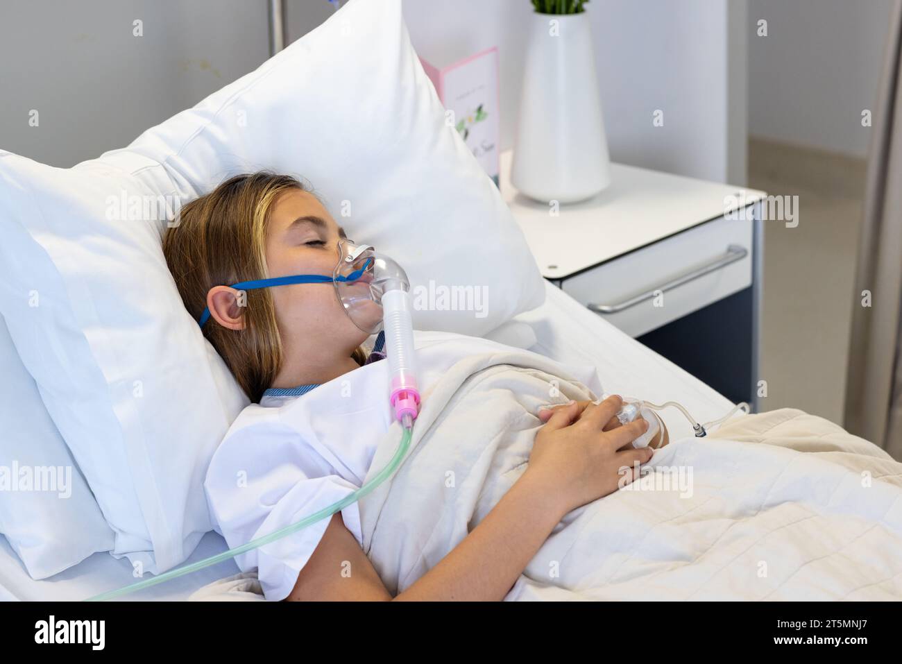 Caucasian girl patient with drip and wearing oxygen mask asleep in ...