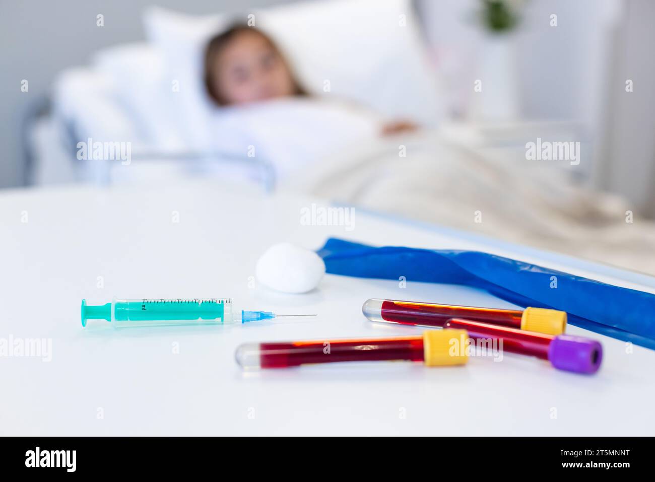 Syringe and blood samples on table, caucasian girl patient in hospital ...