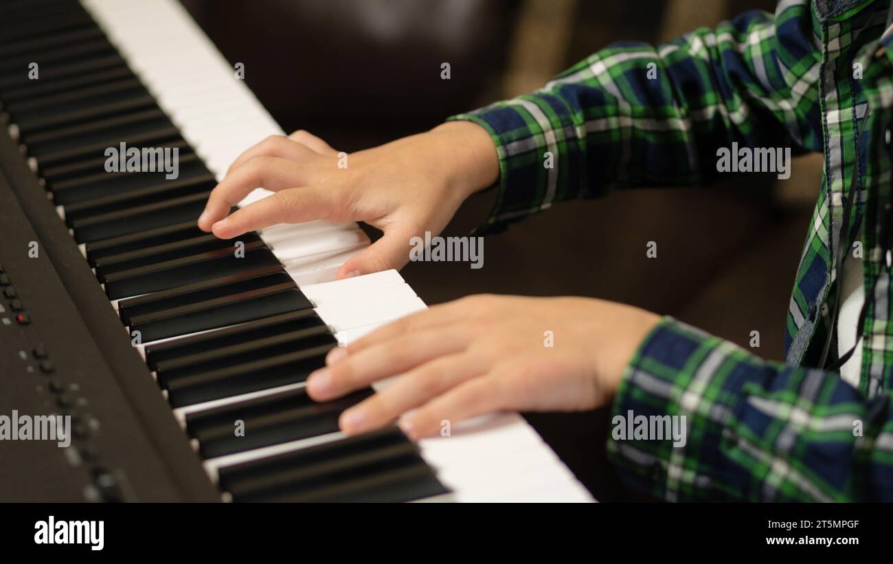 Detailed view of hands playing on the black and white keys of a digital ...