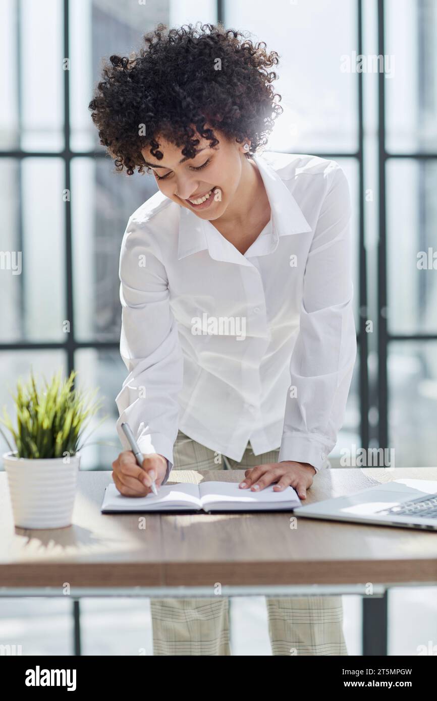 business woman writing at her desk in a modern office Stock Photo - Alamy