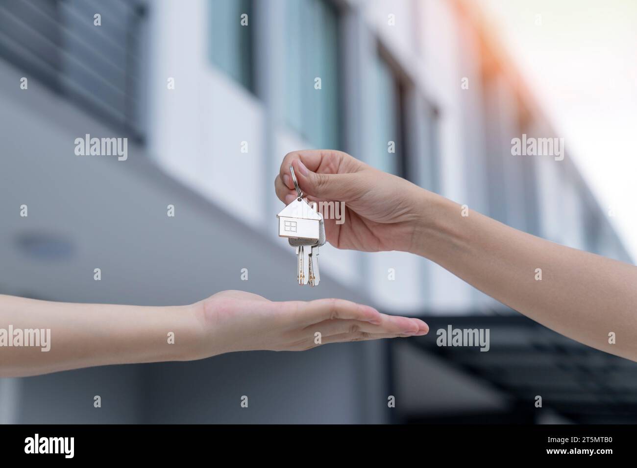 Real estate agent delivering keys house, Hands pass a house key as a ...