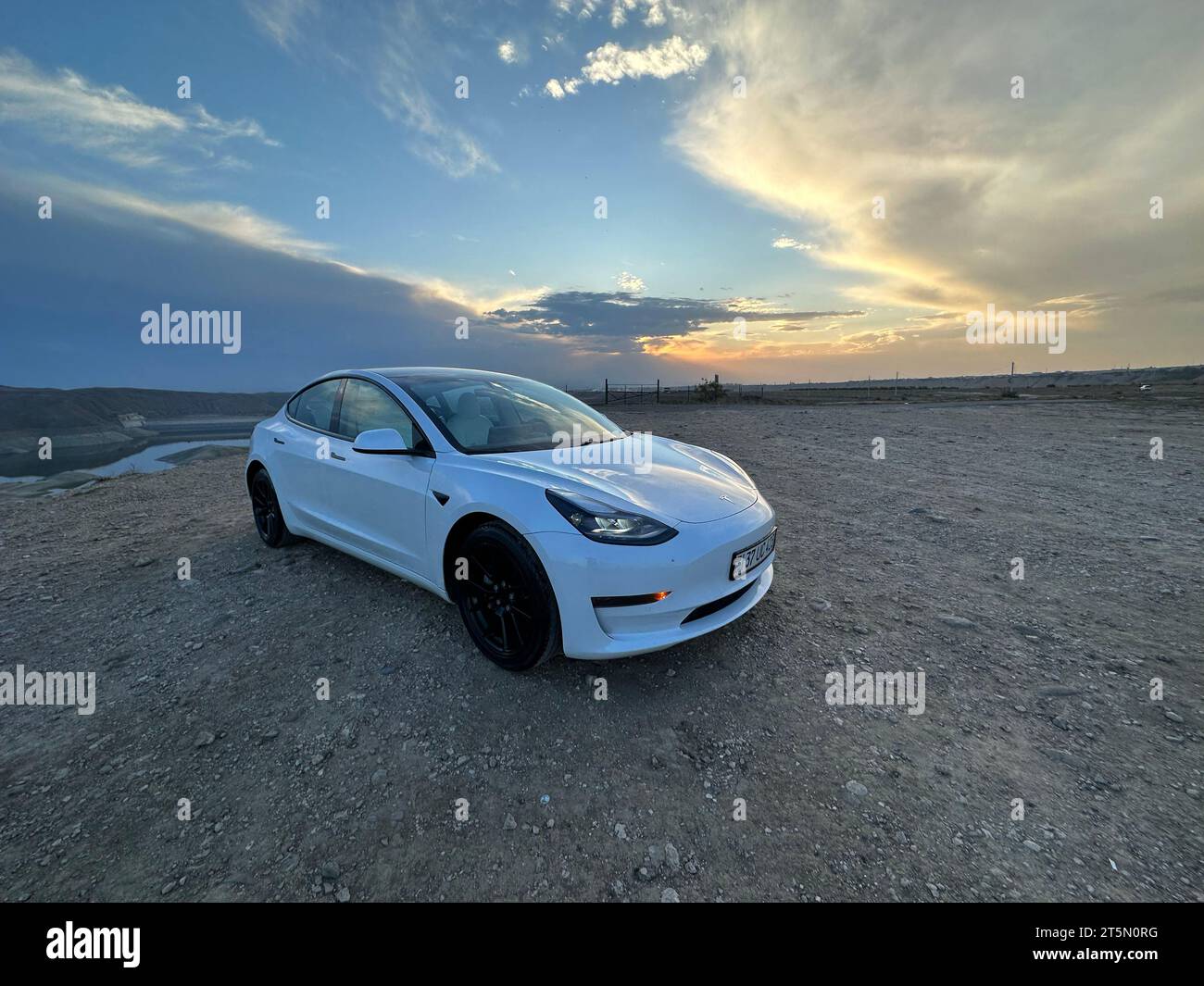 A white Tesla model 3 parked outdoors at sunset Stock Photo - Alamy