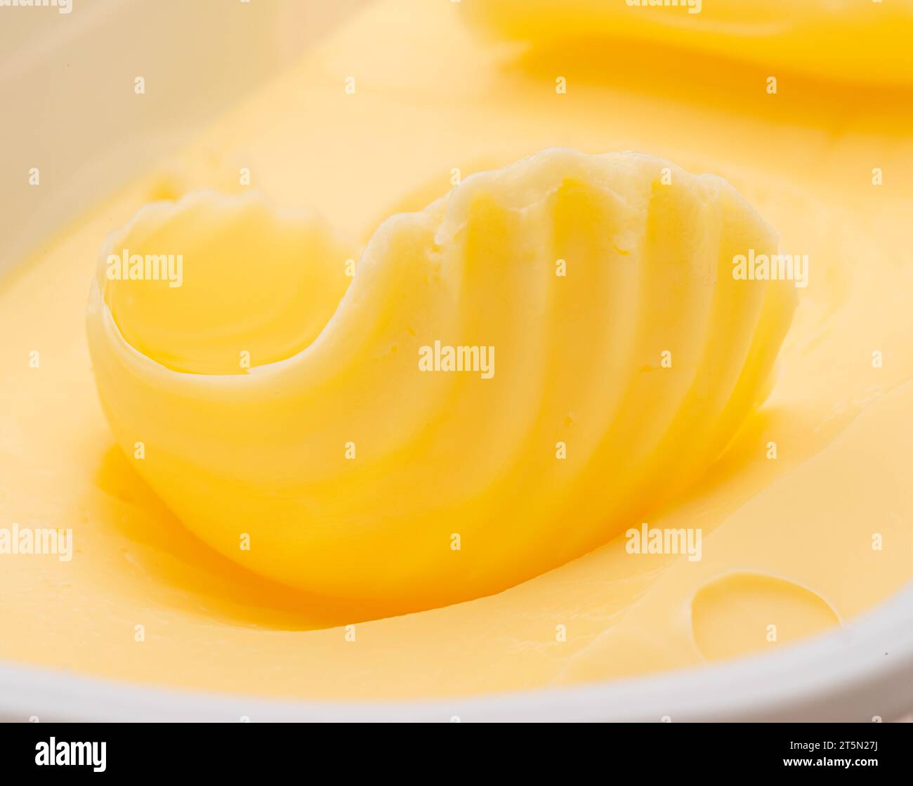 Butter curl over the piece of the butter closeup. Food background Stock ...